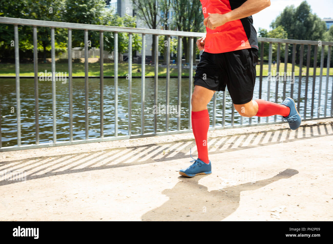 Low Section View Of A Man Running On Sidewalk At Morning Stock Photo ...