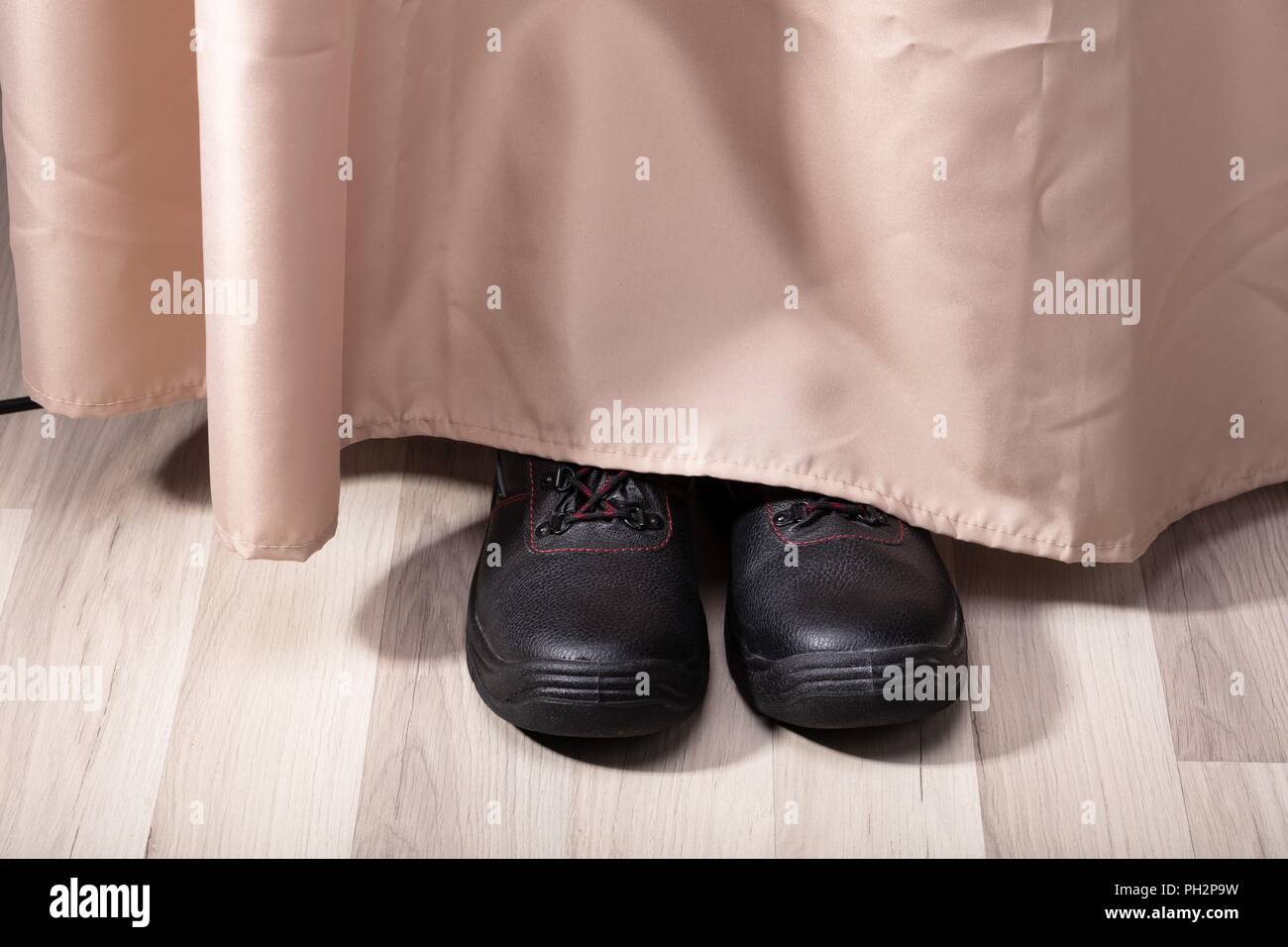 View Of A Person Shoe's Hiding Behind Curtain Stock Photo - Alamy