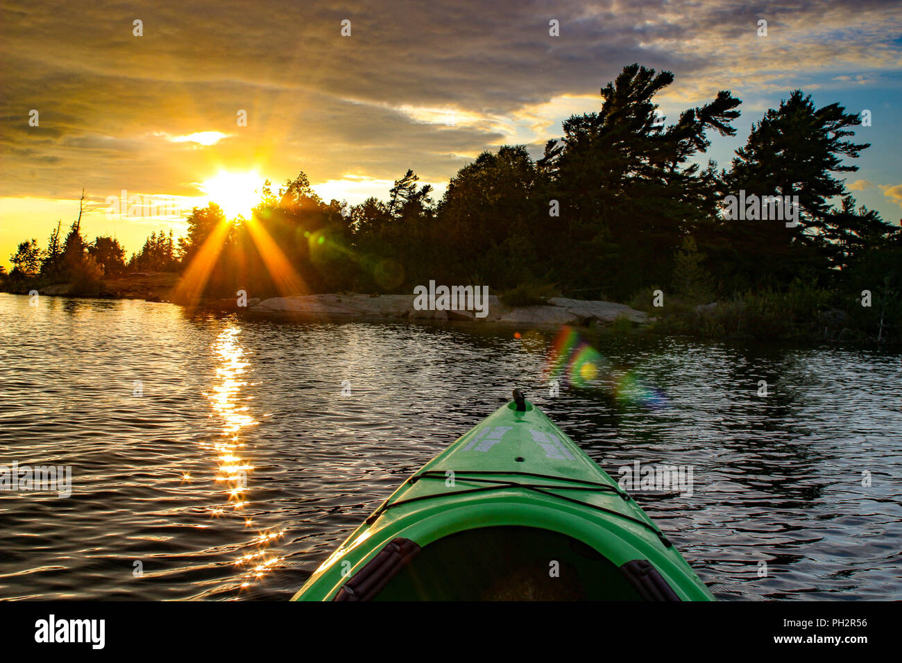 Kayak on a lake at a fiery sunset. Muskoka region Ontario Stock Photo ...