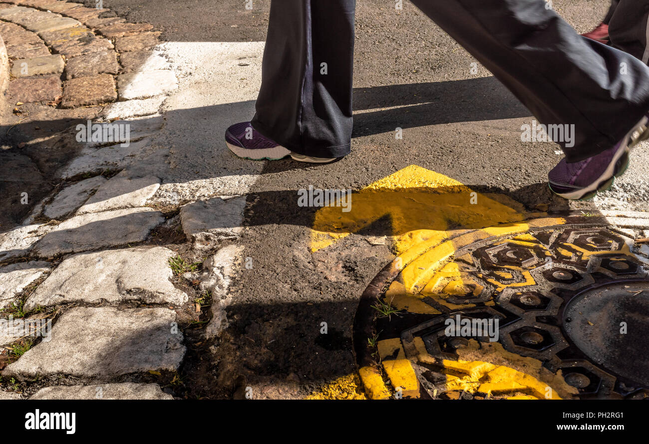Person crossing the street walking over an arrow in another direction ...