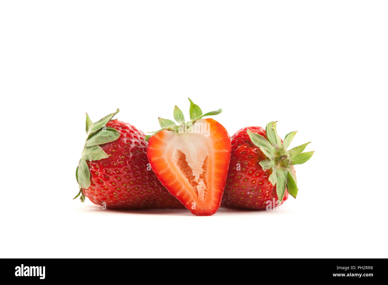 Strawberries isolated on a white background with one cut in half Stock ...