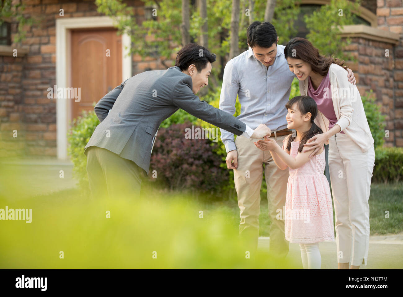 Realtor giving young family keys to new house Stock Photo - Alamy