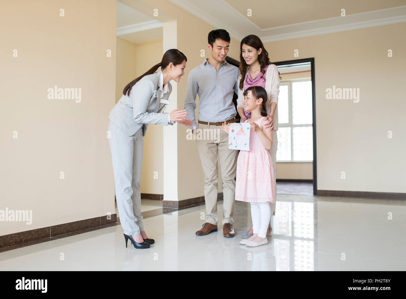 Cute little girl showing her drawing to realtor Stock Photo - Alamy