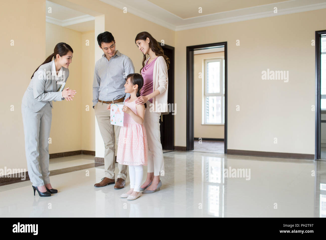 Cute little girl showing her drawing to realtor Stock Photo - Alamy