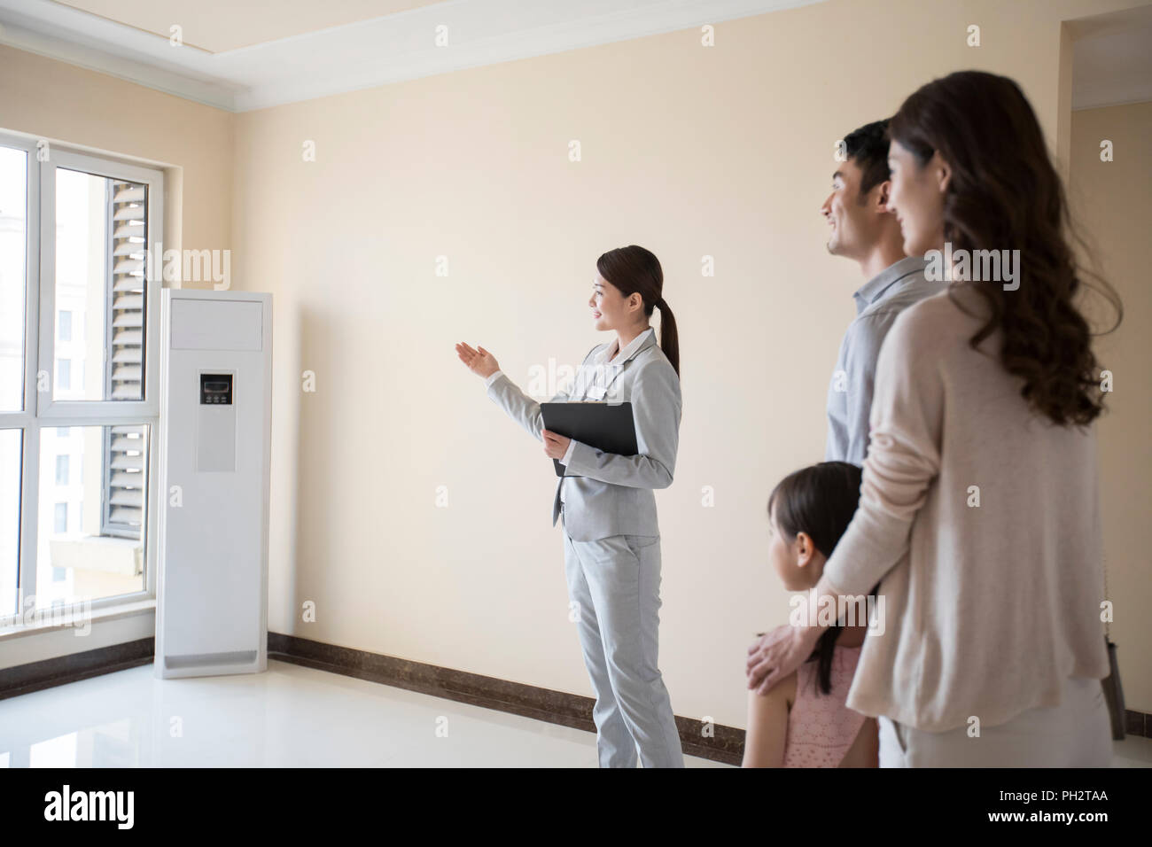 Realtor showing new house to young family Stock Photo - Alamy