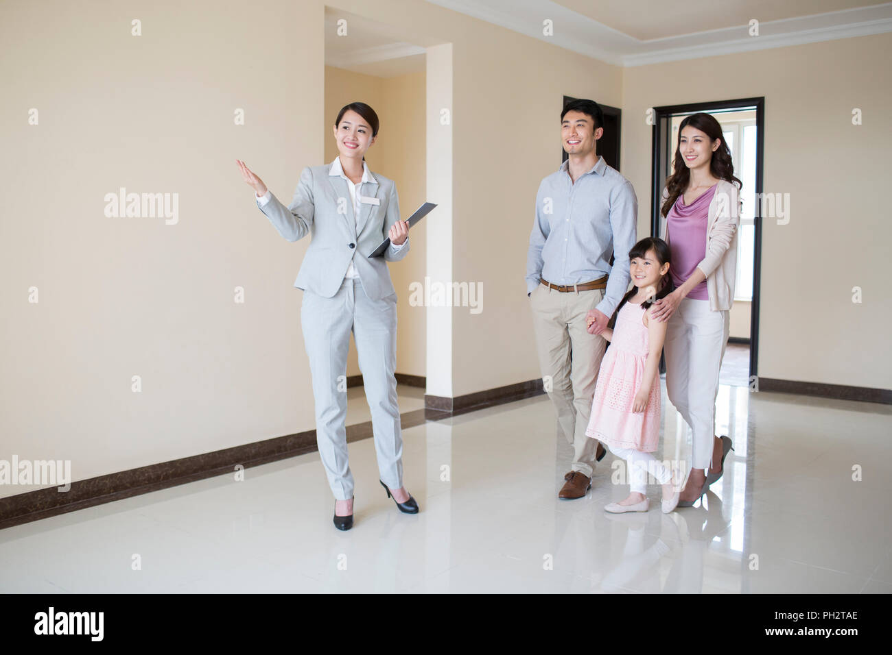Realtor showing new house to young family Stock Photo - Alamy