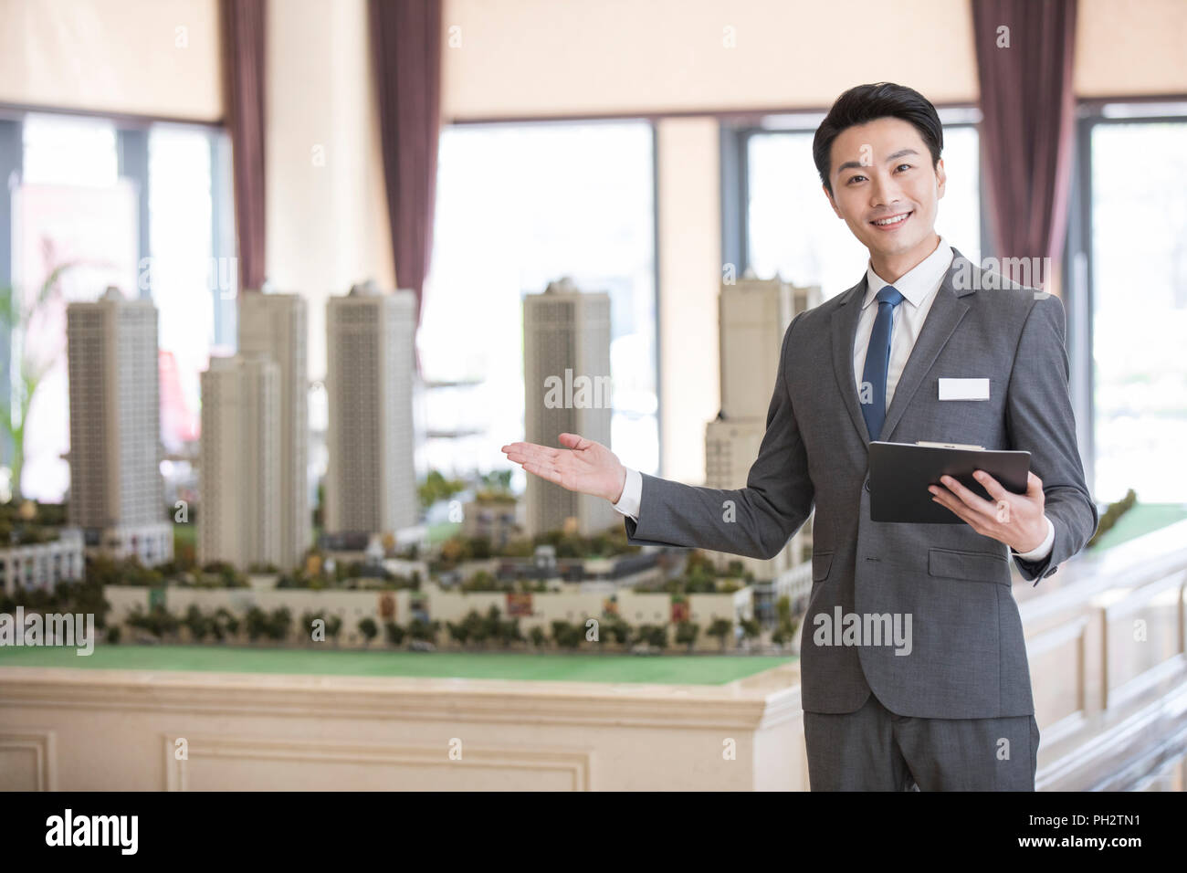 Confident realtor in sales center Stock Photo - Alamy