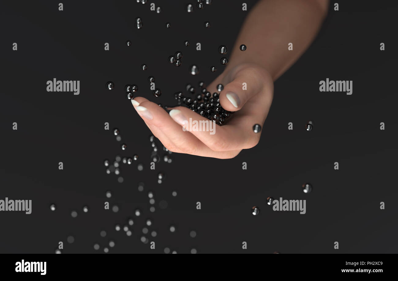 black balls fall into the hand Stock Photo - Alamy