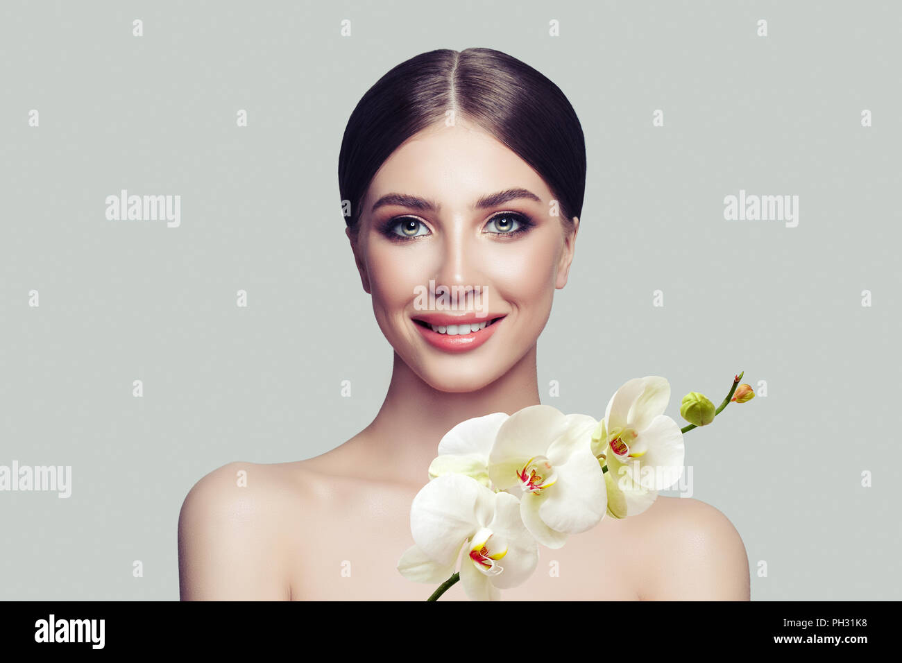 Happy woman spa model with healthy skin, cute smile and orchid flowers ...