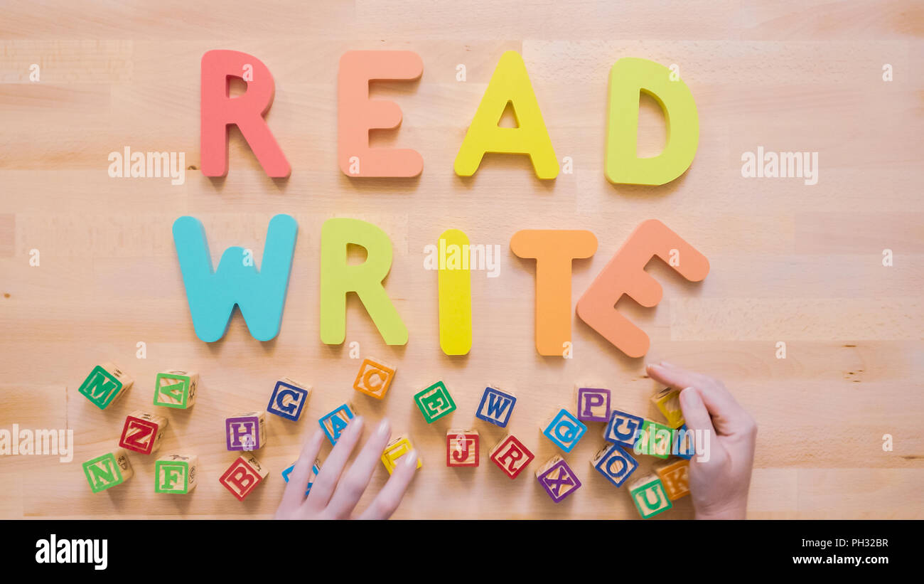 Words READ and WRITE from multicolor wooden letters on wooden table ...