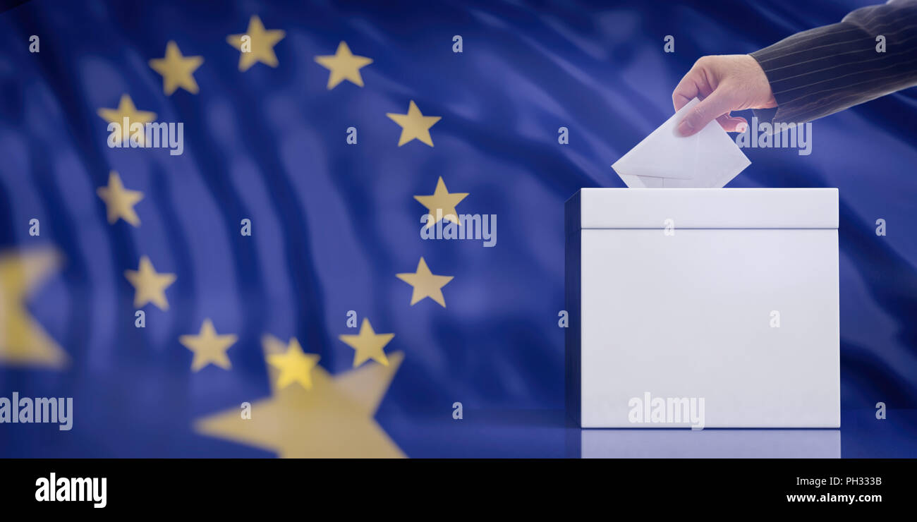 EU elections concept. Hand inserting an envelope in a white blank ...