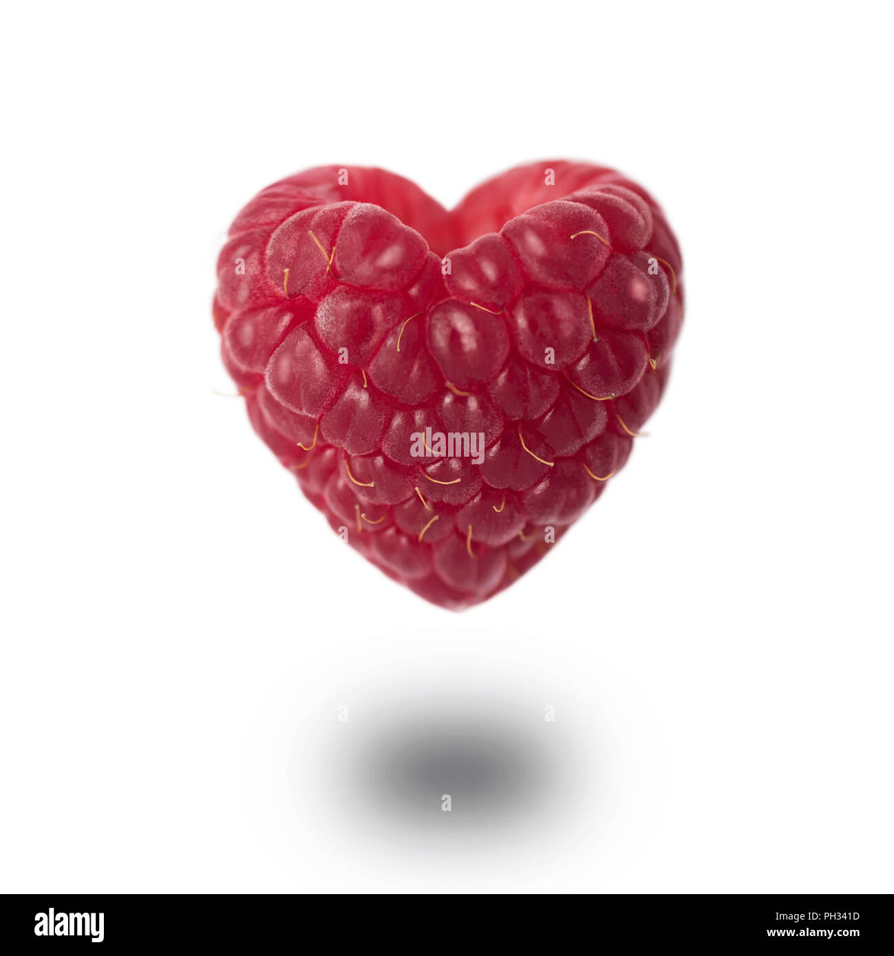 Raspberry in the shape of a heart on a white background Stock Photo - Alamy