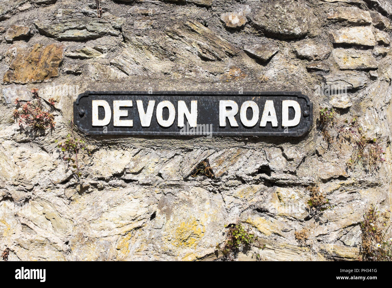 Old street sign for Devon Road in Salcombe mounted on old stone wall ...