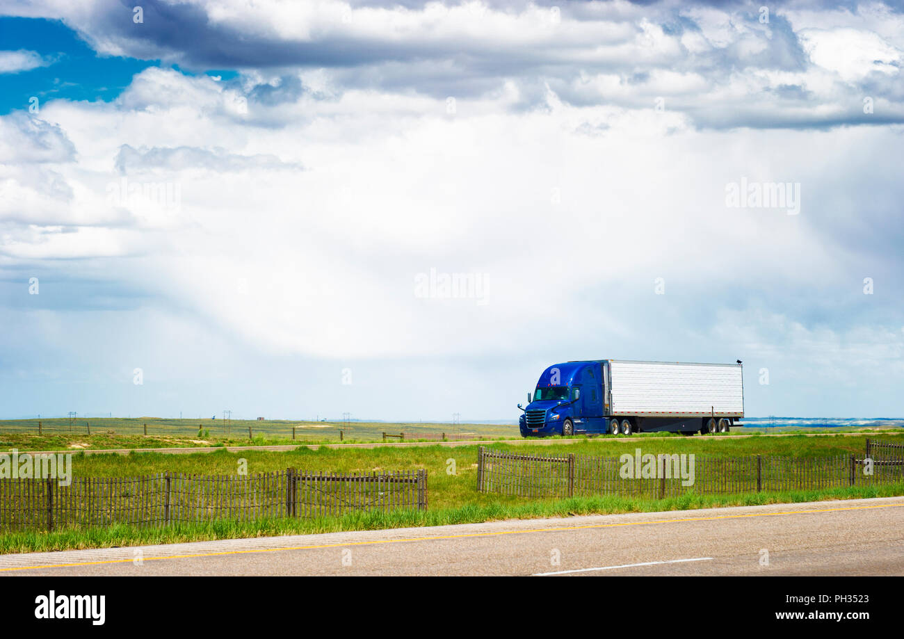 A semi travel westbound on highway 80 with views of Wyoming's open ...