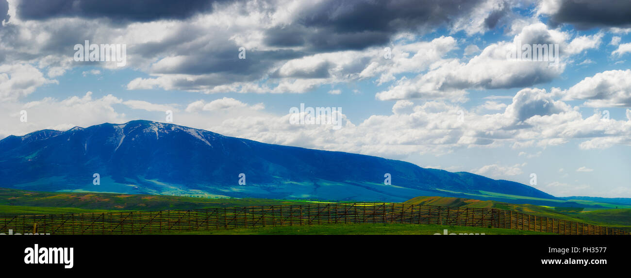 Panoramic view of Wyoming's ominous cloudy skies over open fields and ...