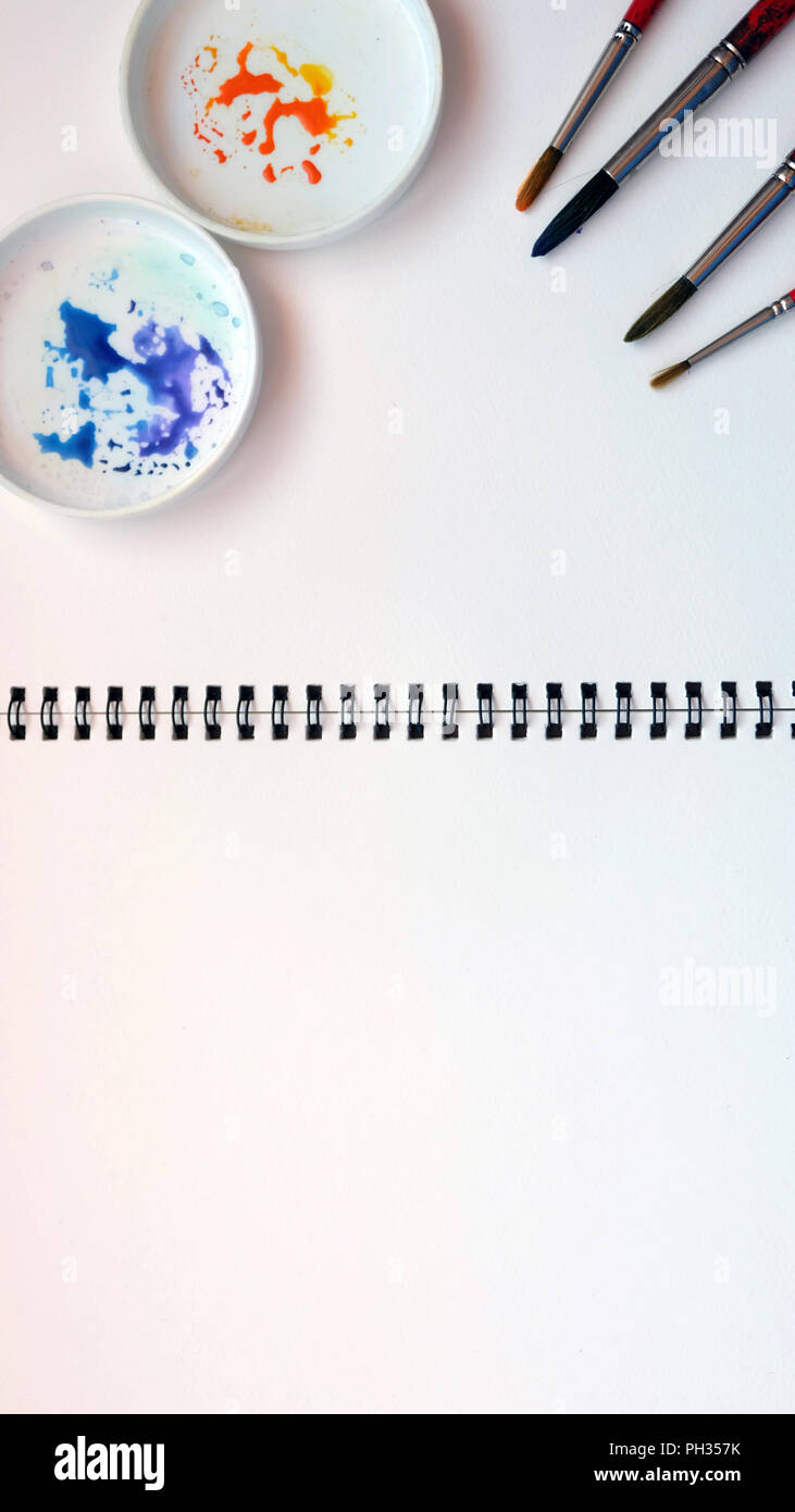 Flat lay of water color brushes and mixing trays with orange and blue ...