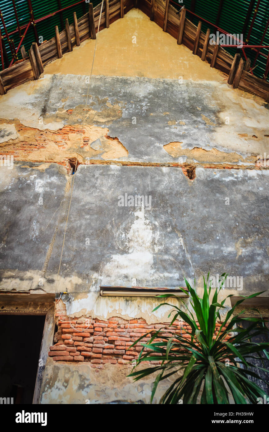 Gable end of an old buddhist church with old door and grungy brick wall ...