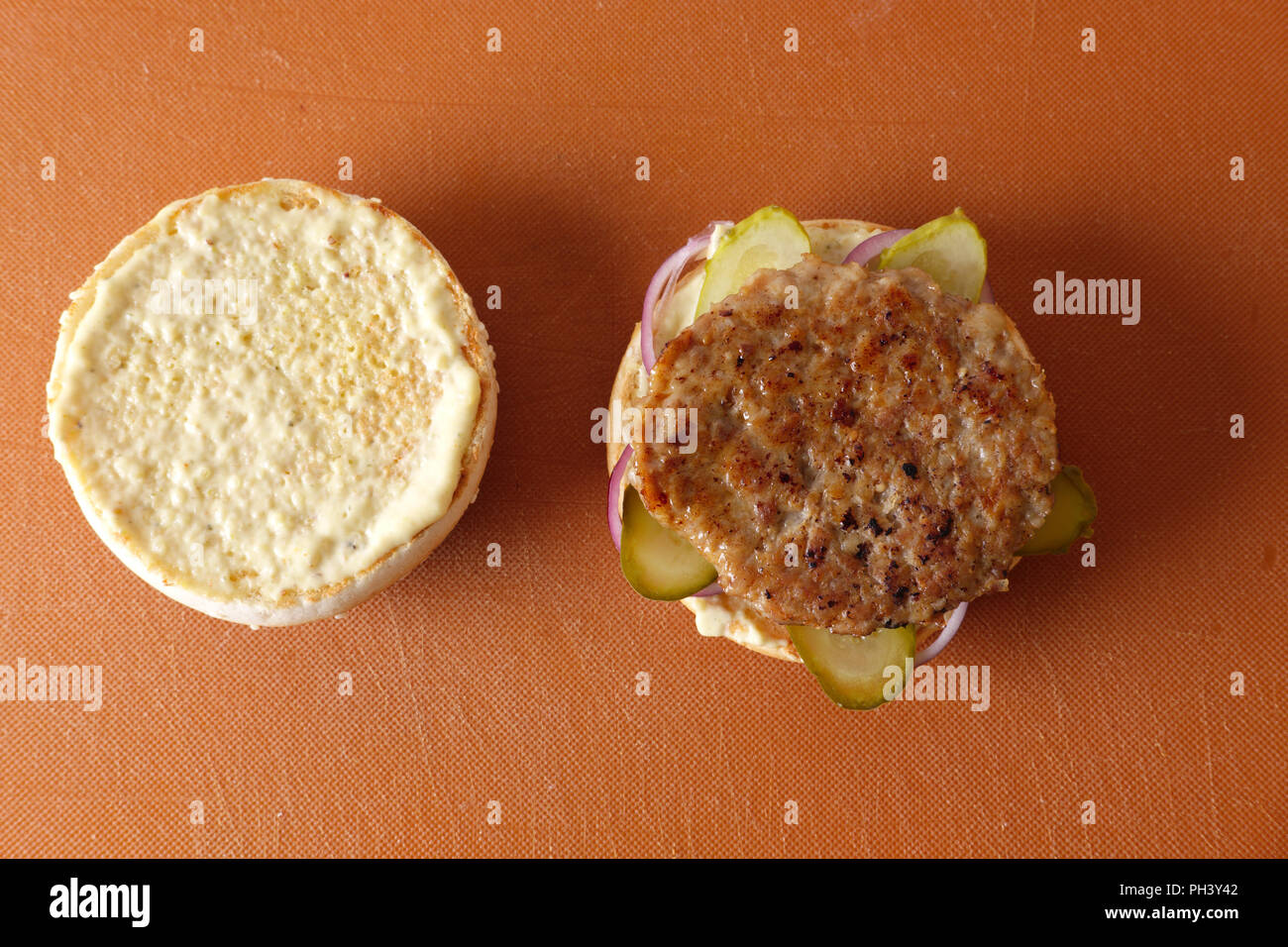 Making burger. Putting ingredients on bun Stock Photo - Alamy
