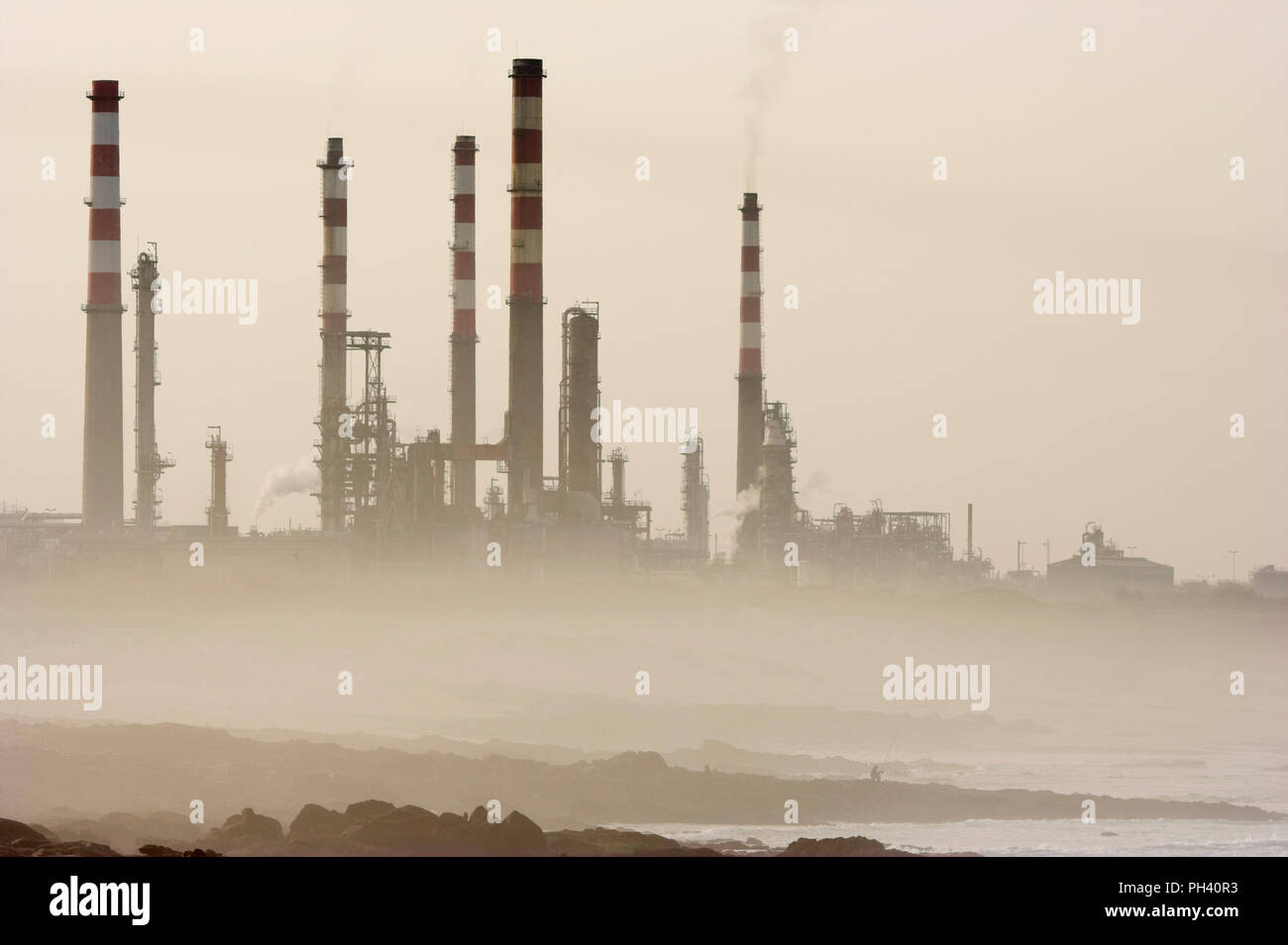 Oil refinery by the sea in the middle of fog, clouds and pollution ...