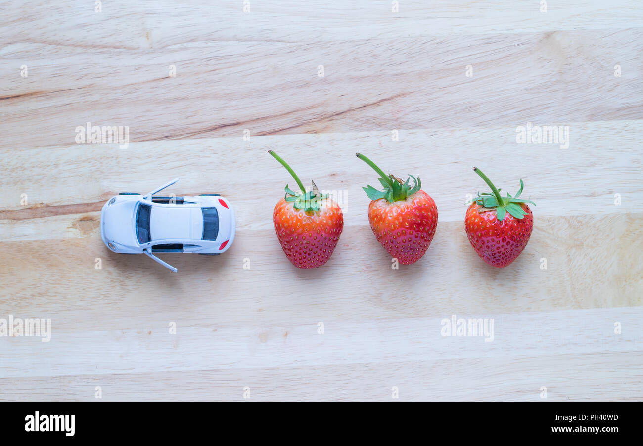 Red Strawberry and toy car on wooden pattern background Stock Photo - Alamy