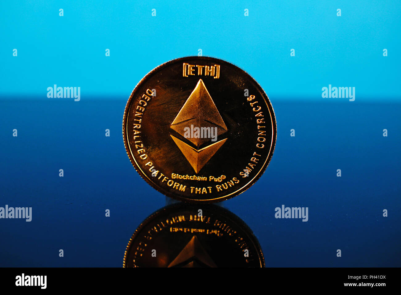 Etherum money crypto currency coin on reflective colorful background. Gold Stock Photo - Alamy