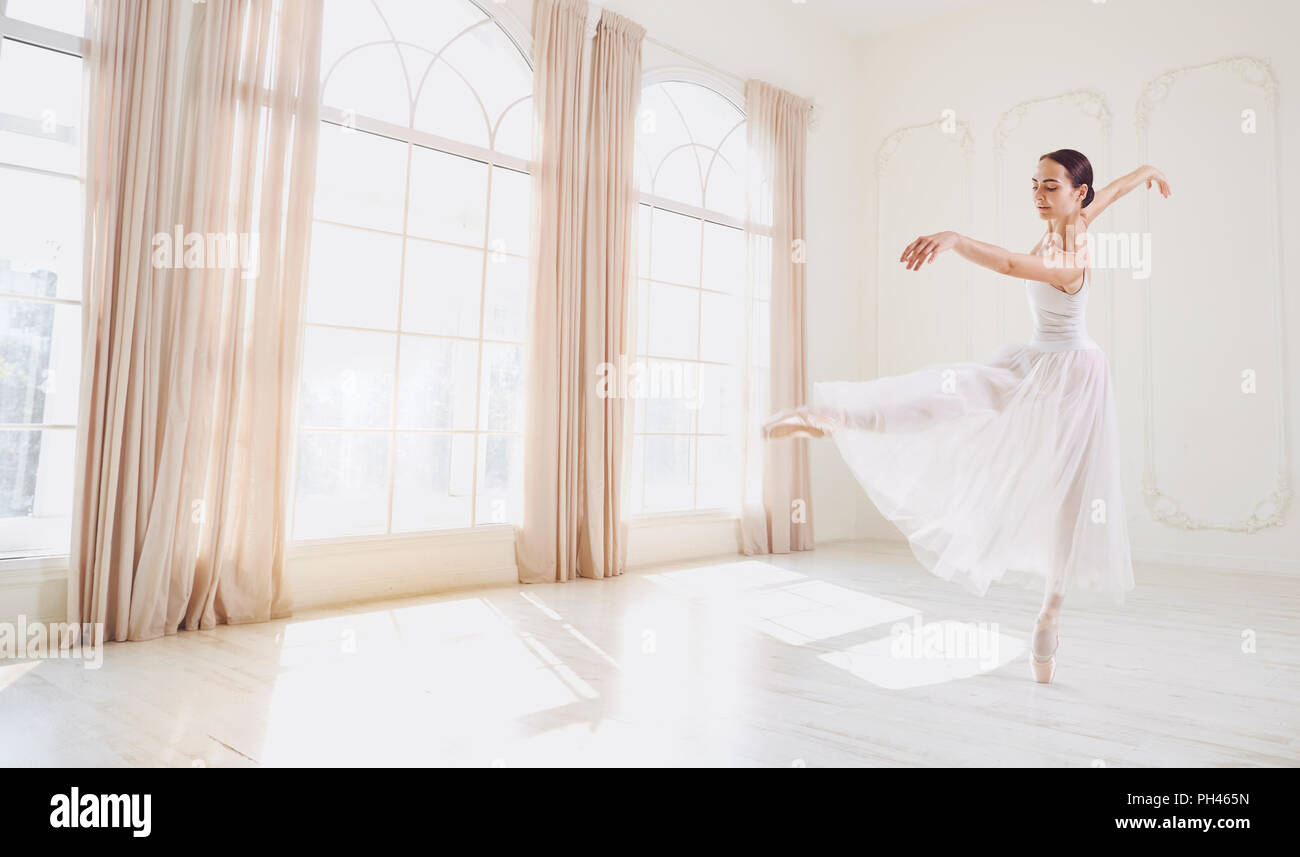 Ballerina dancing in a studio on background window Stock Photo - Alamy
