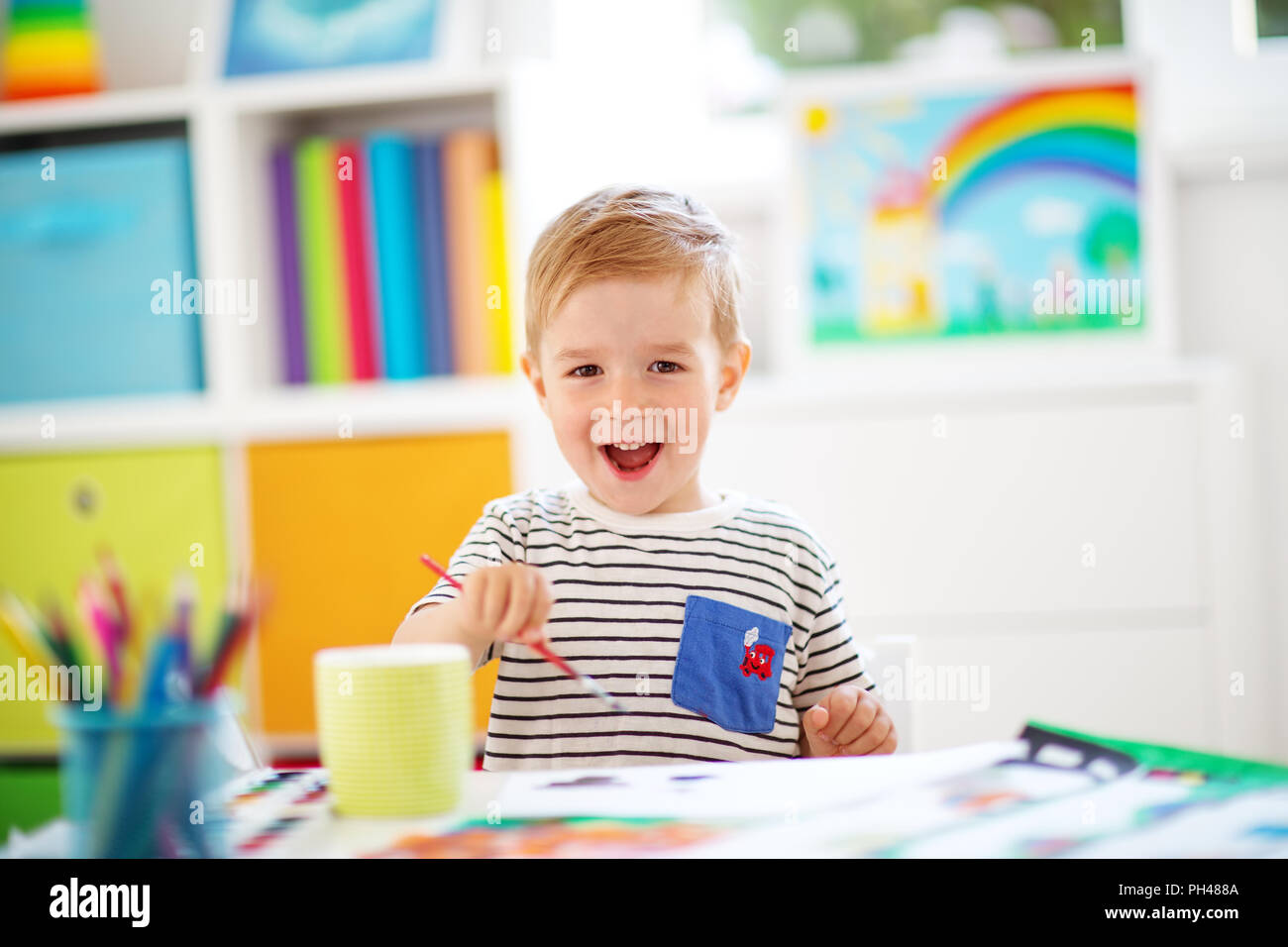 Little child drawing on the paper in room Stock Photo - Alamy