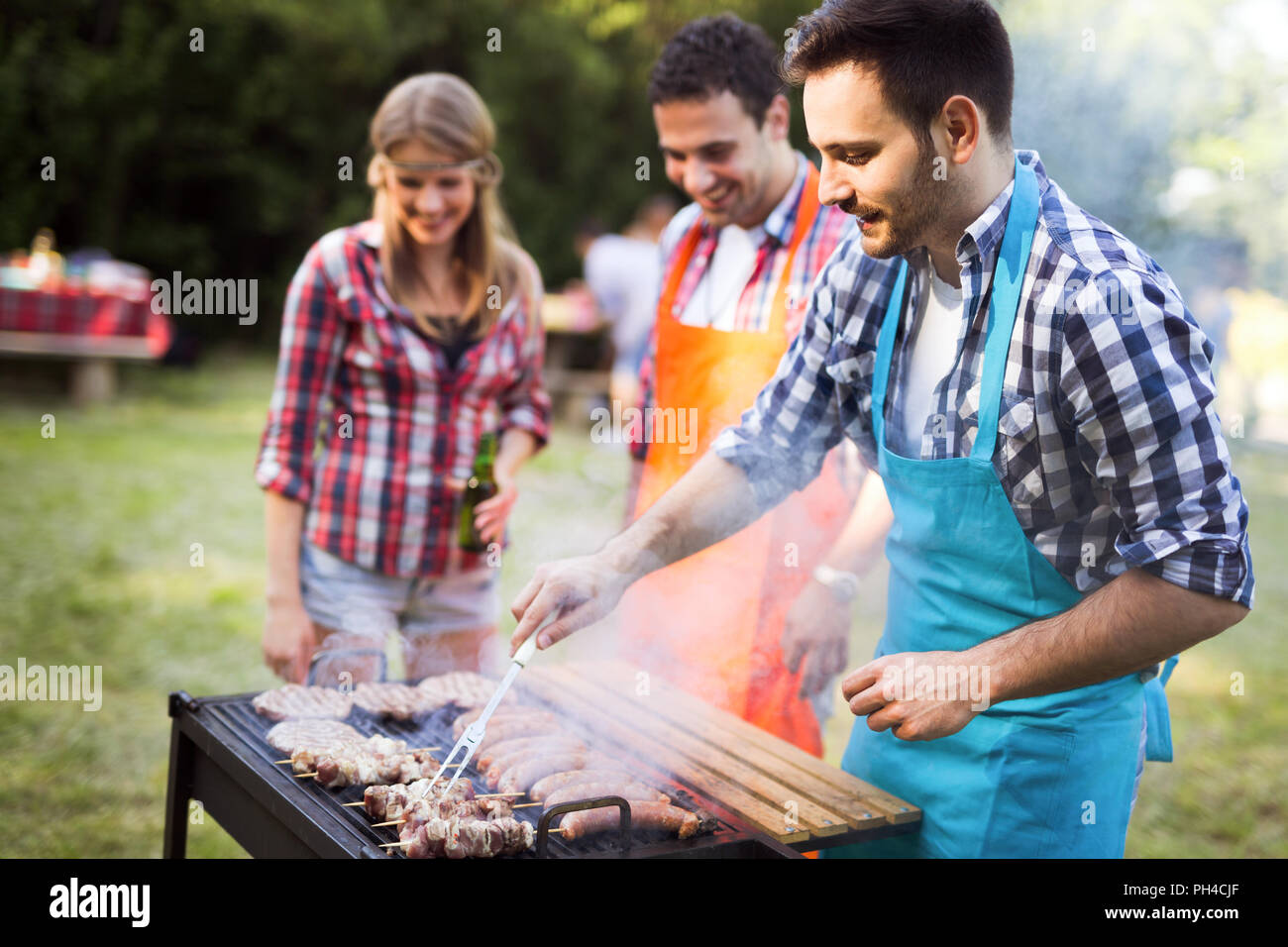 Happy friends enjoying barbecue party Stock Photo - Alamy