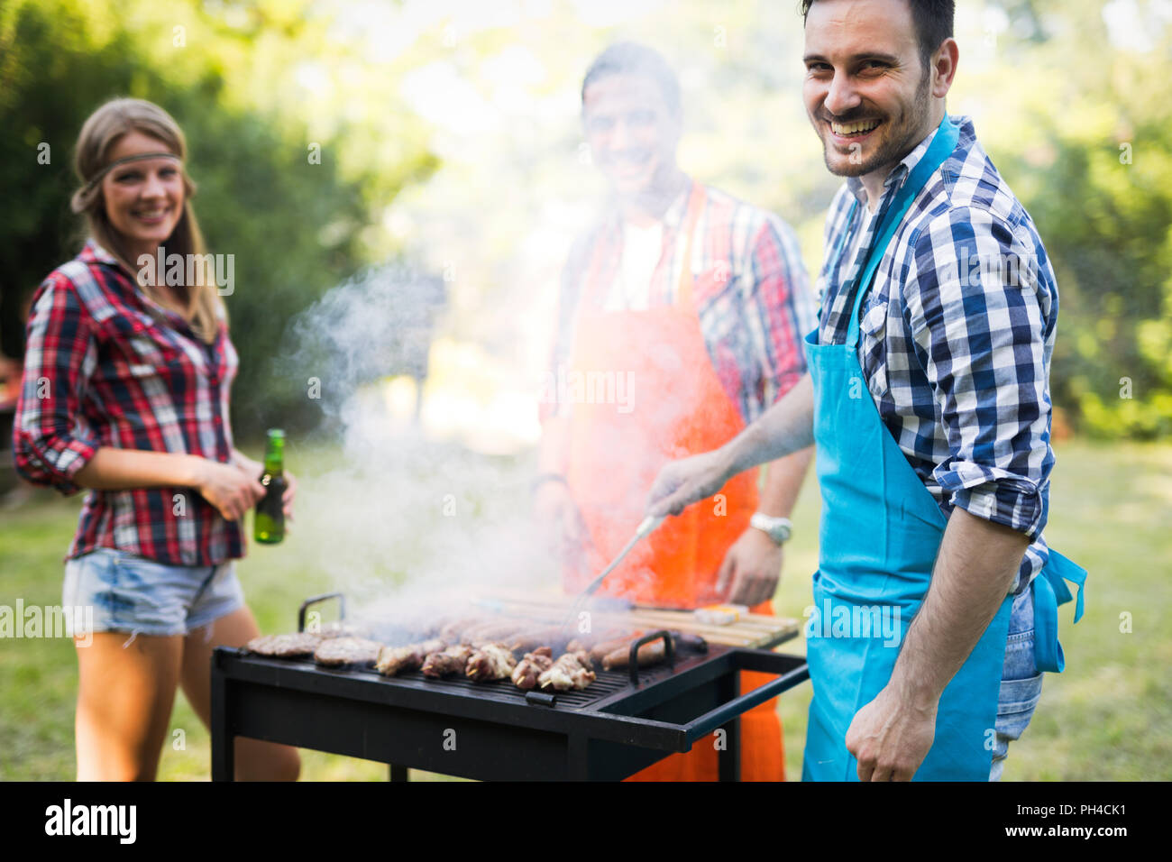 Happy friends enjoying barbecue party Stock Photo - Alamy