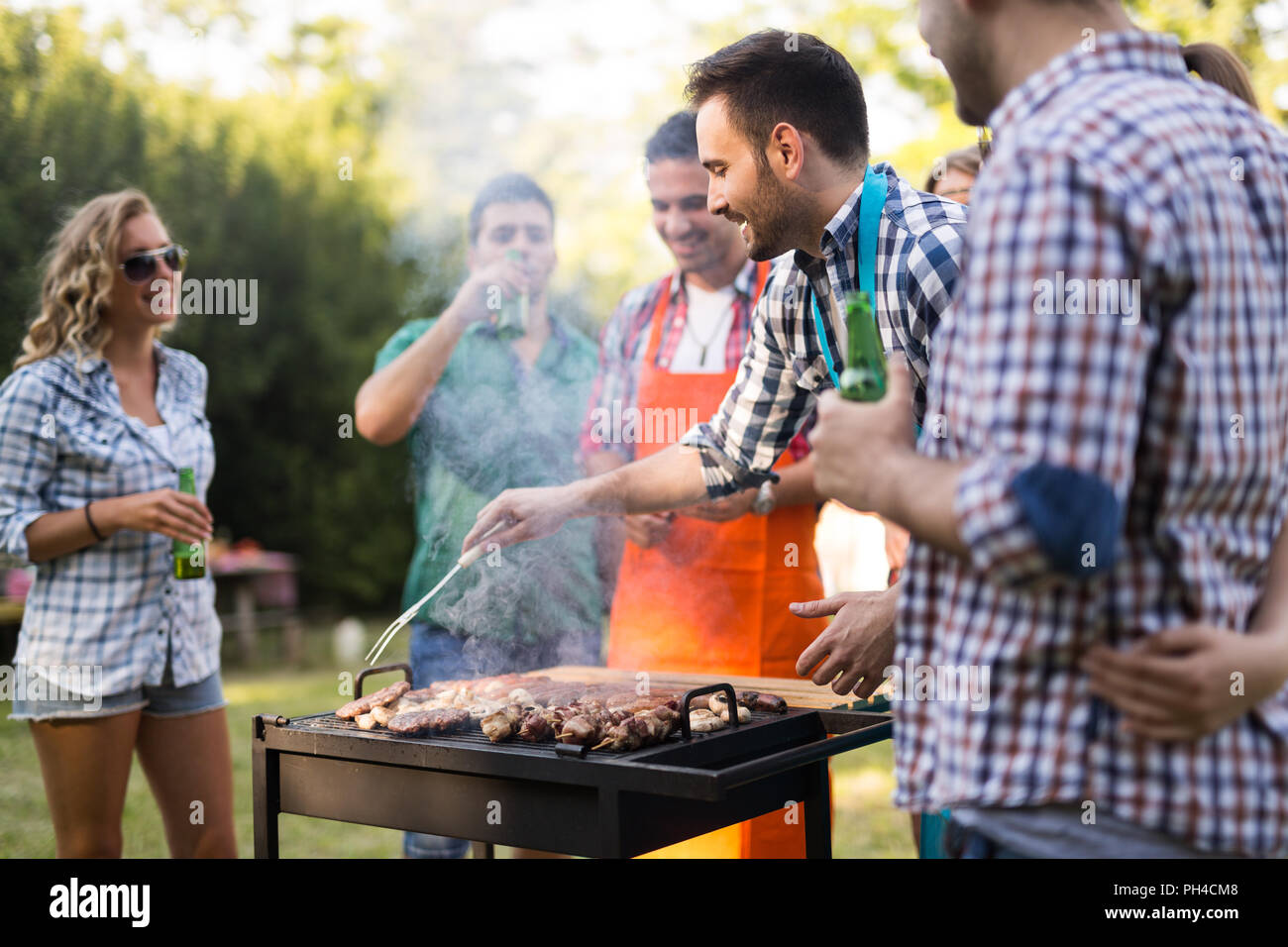 Friends enjoying bbq party Stock Photo - Alamy