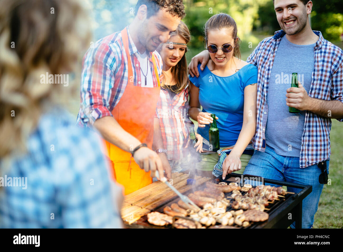 Happy friends enjoying barbecue party Stock Photo - Alamy