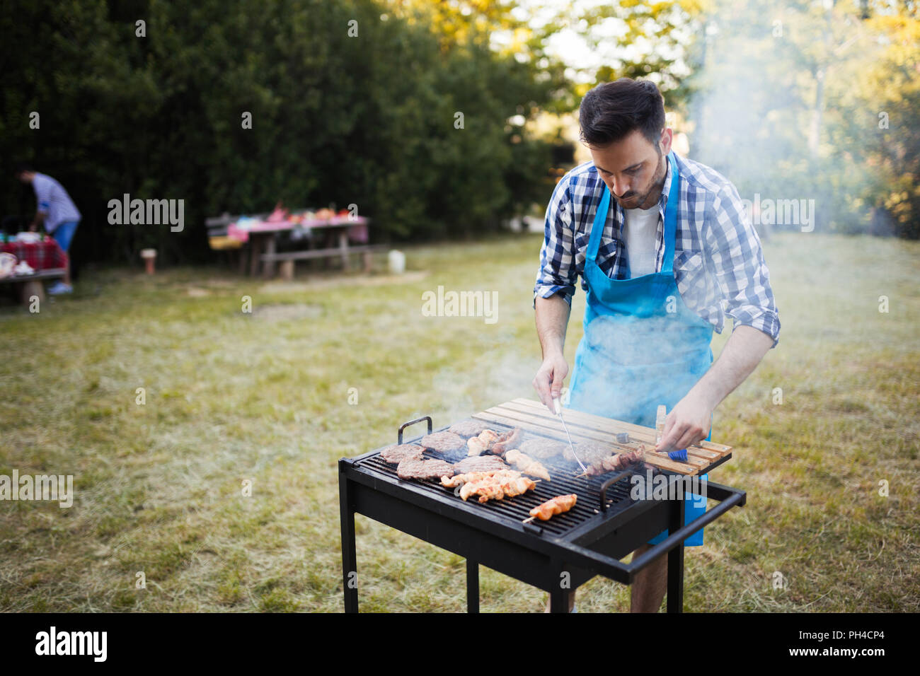 Handsome male preparing barbecue Stock Photo - Alamy