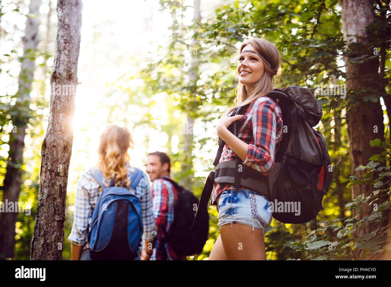 Group of backpacking hikers going for forest trekking Stock Photo - Alamy