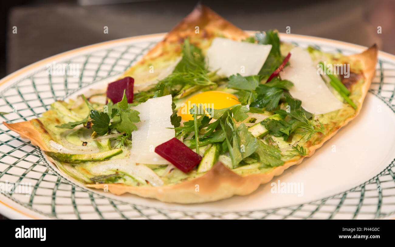 Open faced spring vegetable lasagna with an egg in the center Stock ...