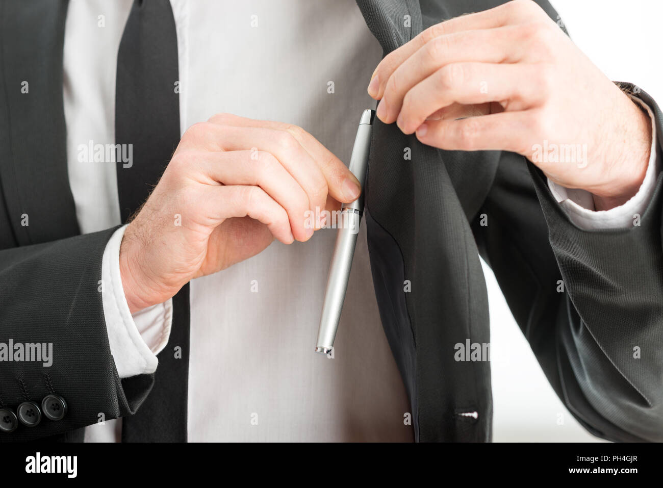Businessman removing a pen from the pocket of his suit jacket, close up ...