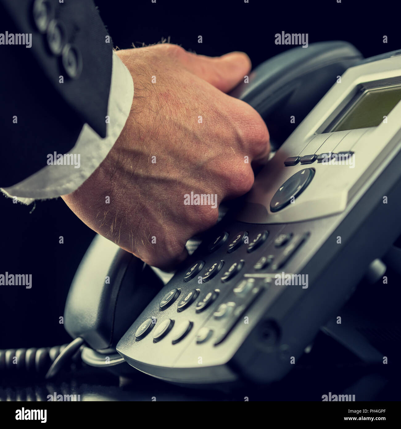 Retro image of a businessman making a call on a landline telephone ...