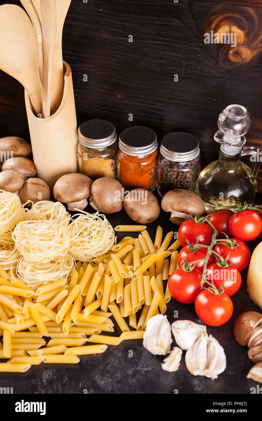 Italian cuisine from raw uncooked pasta next to fresh vegetables ...