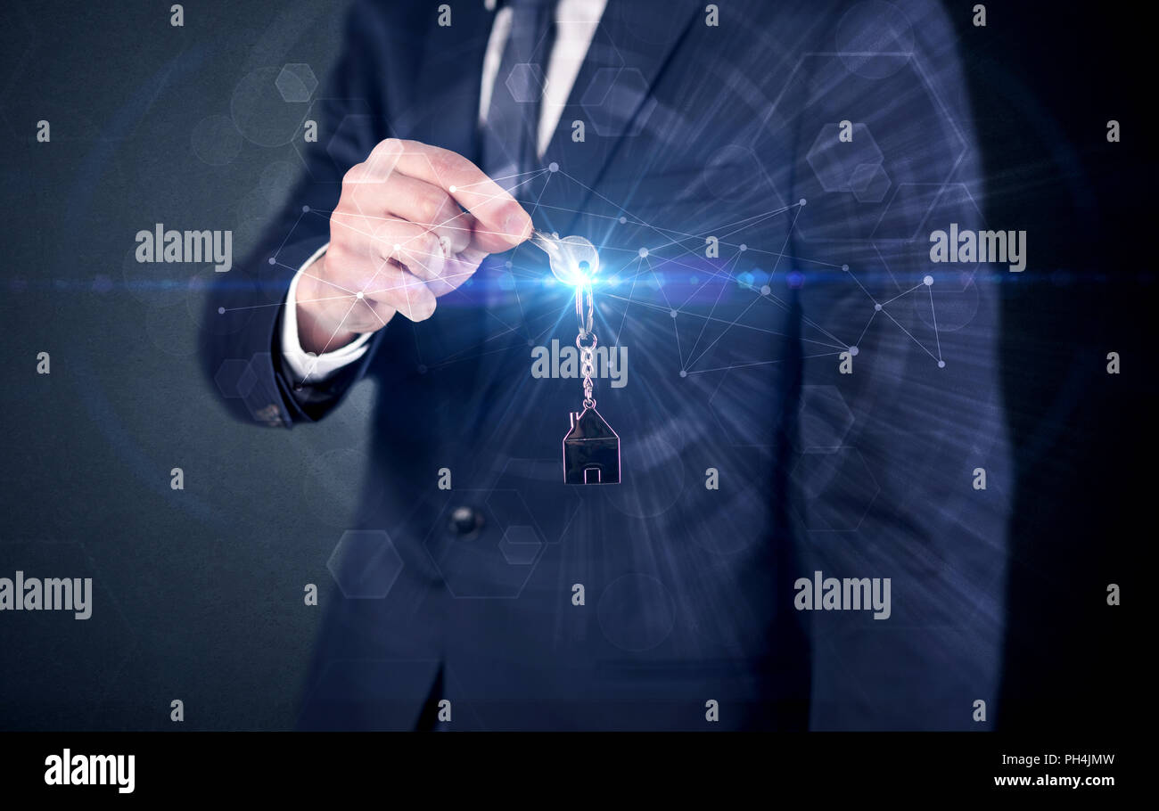 Businessman in suit holding over a key with connection concept around ...