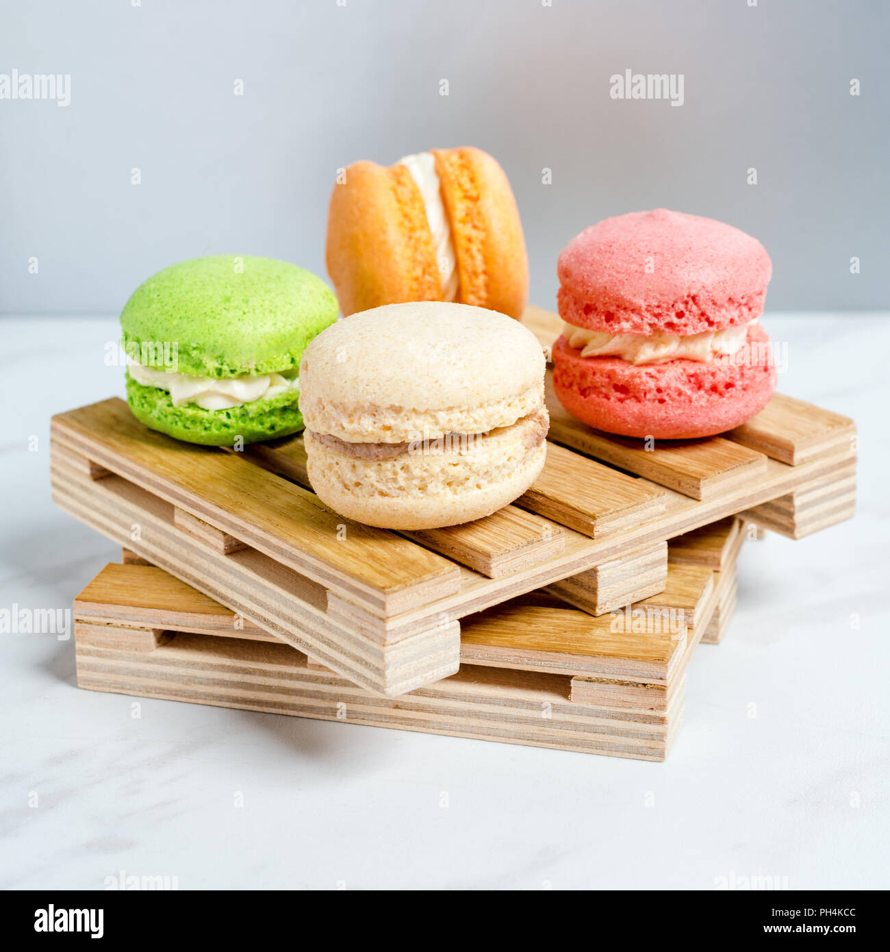 Sweet and colourful macaroons served on little wooden pallets on a ...