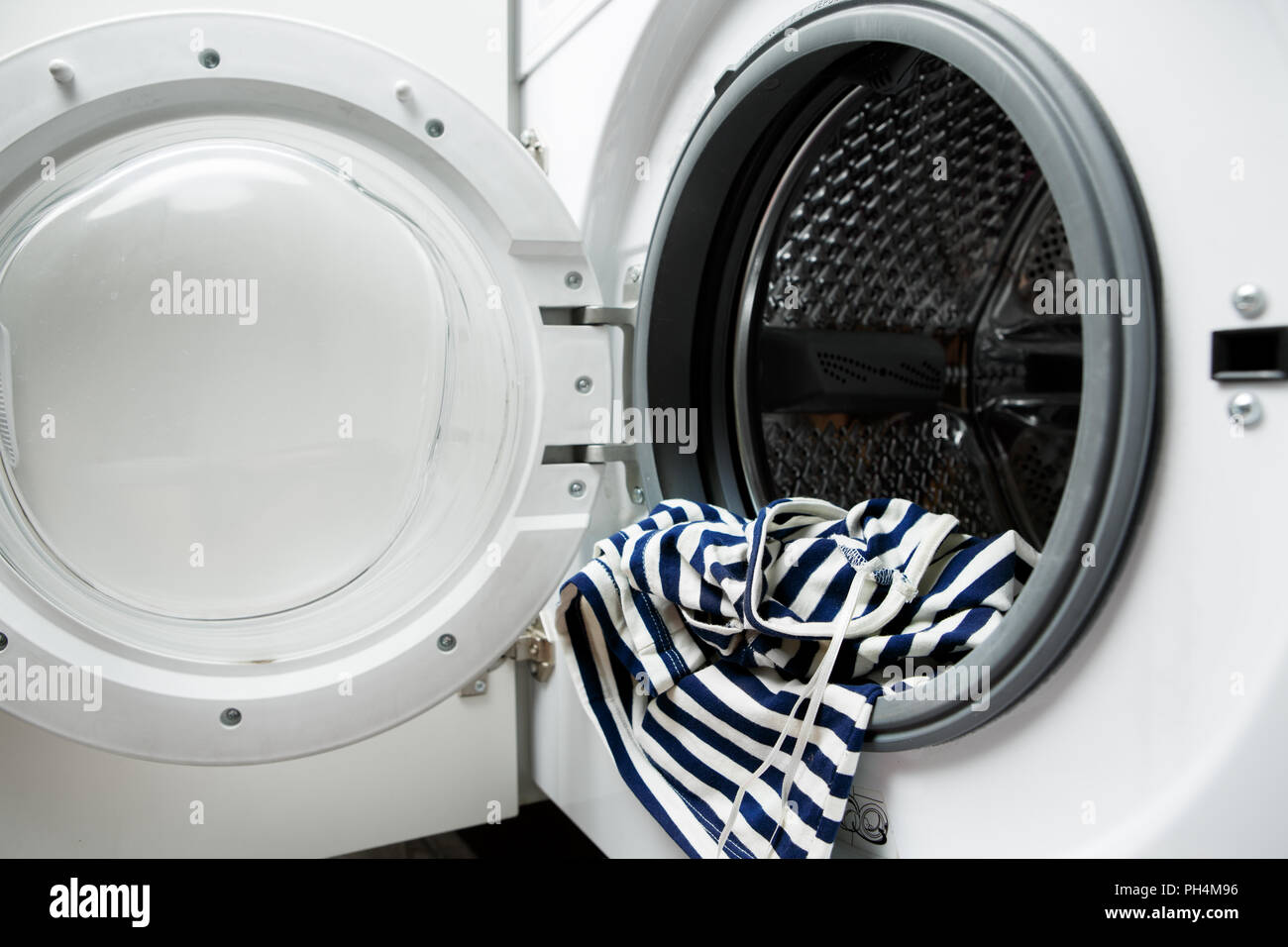 Photo of open washing machine with striped cloth Stock Photo - Alamy