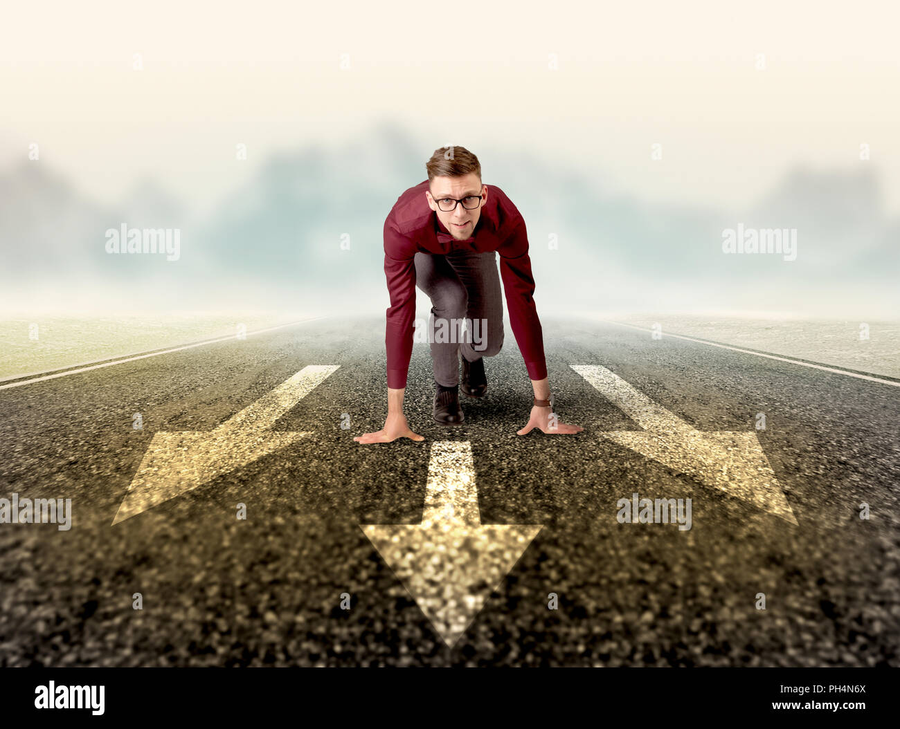 Young determined businessman kneeling before three arrows Stock Photo ...
