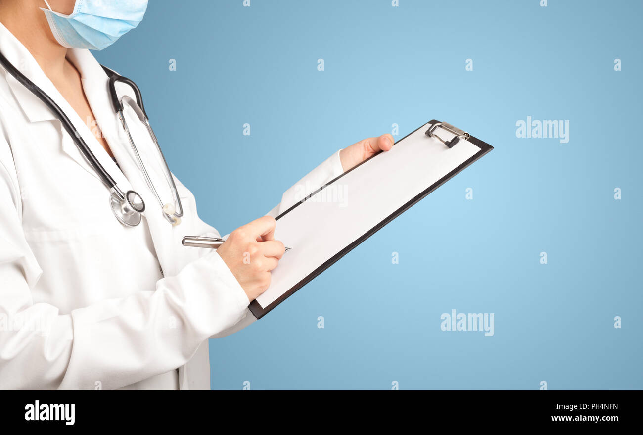 Female doctor holding notepad with blue background Stock Photo - Alamy