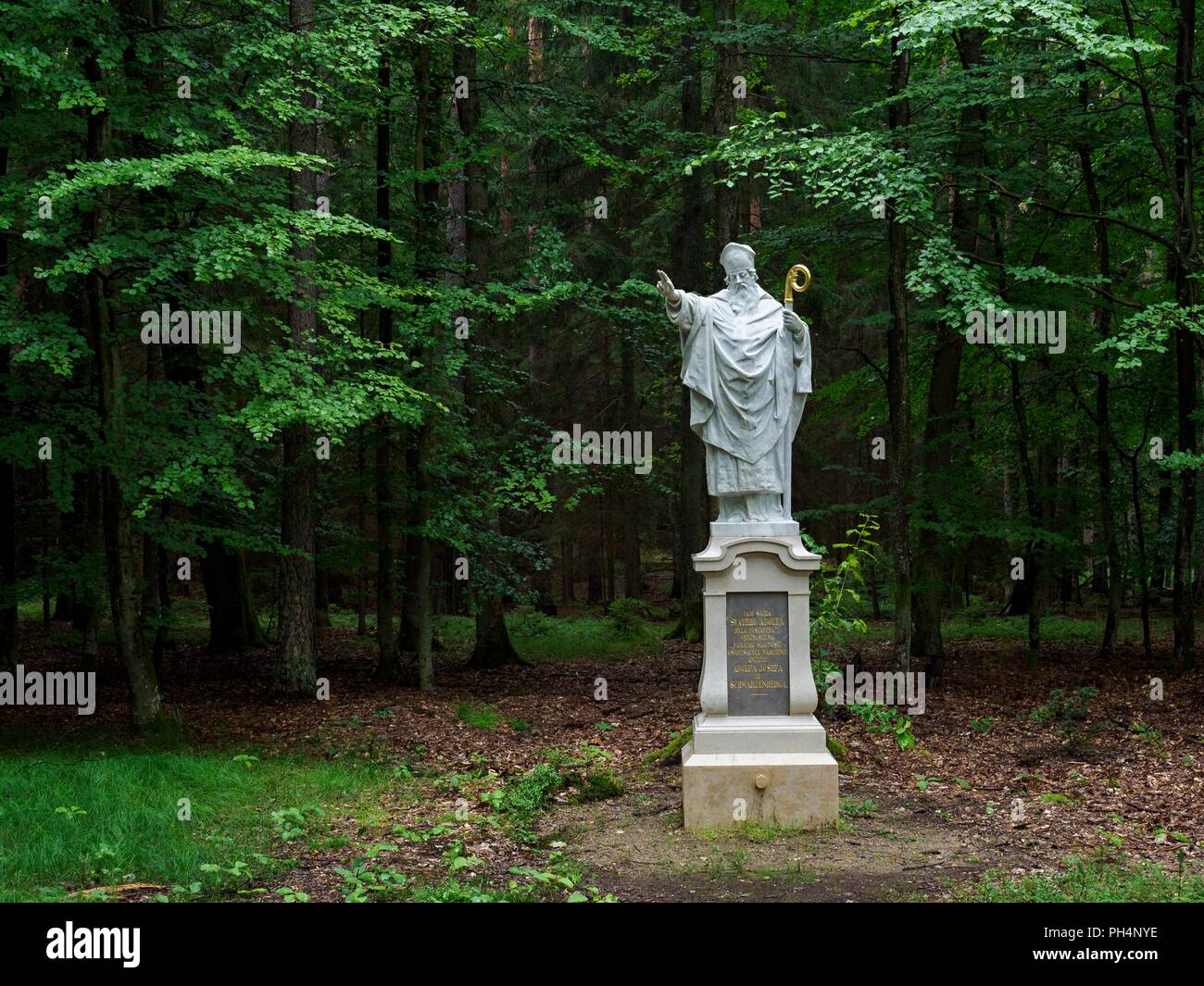Statue of St. Adolf with a golden crutch at the crossroads of forest ...