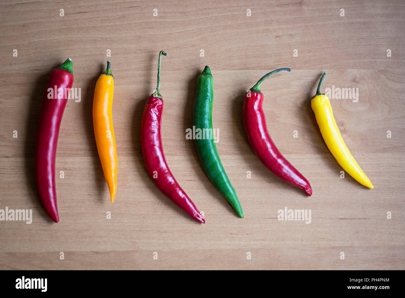 chilli peppers on wooden background Stock Photo - Alamy