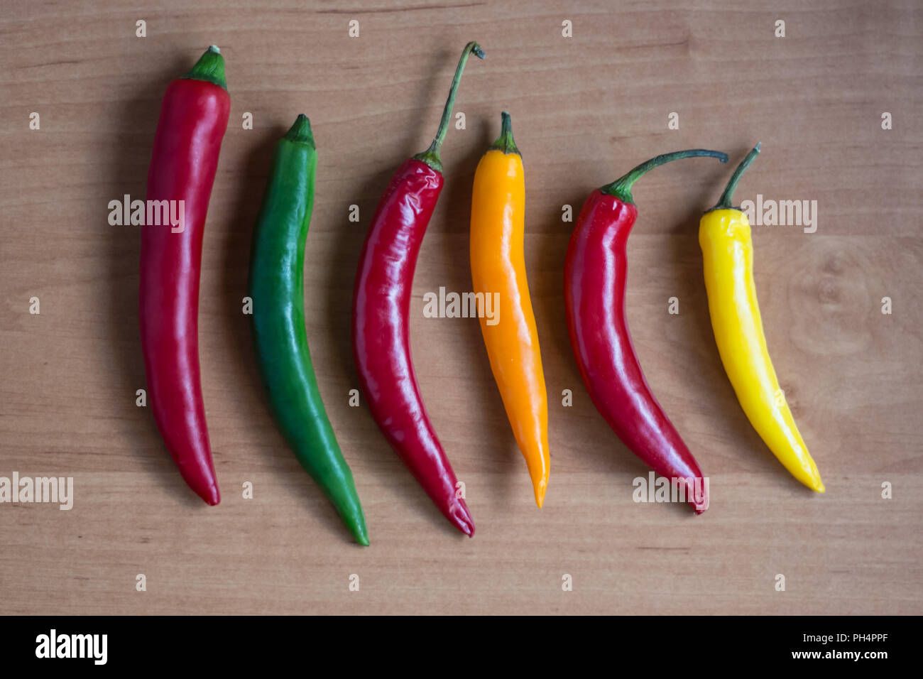 chilli peppers on wooden background Stock Photo - Alamy