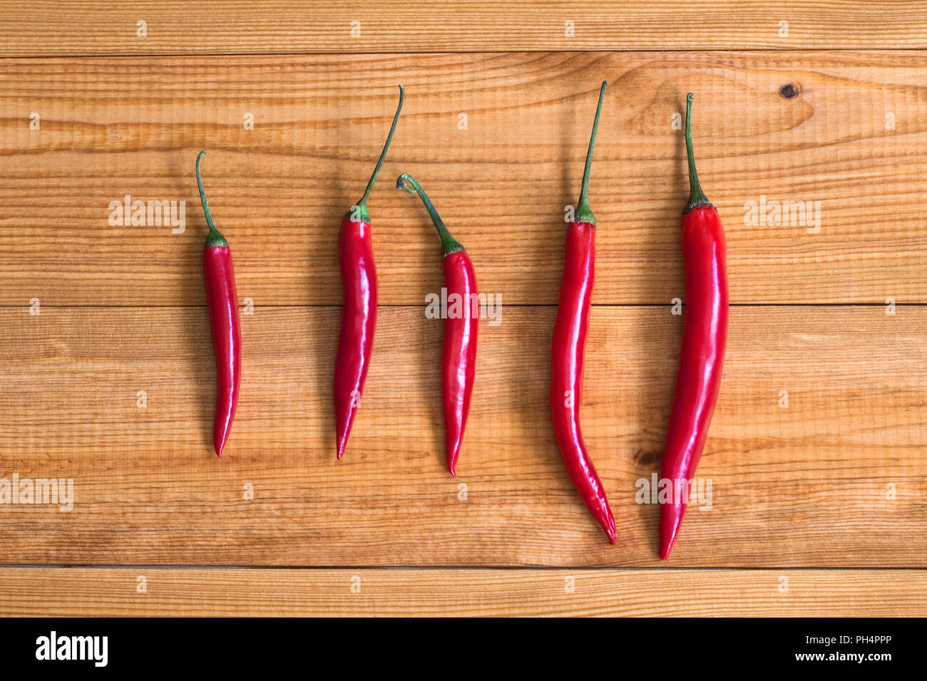 chilli peppers on wooden background Stock Photo - Alamy