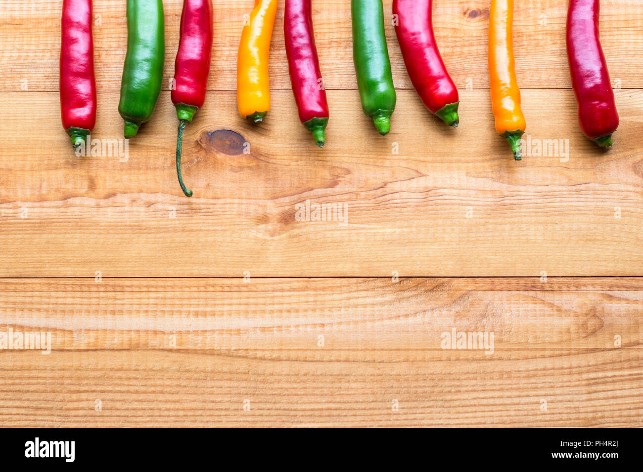 chilli peppers on wooden background Stock Photo - Alamy