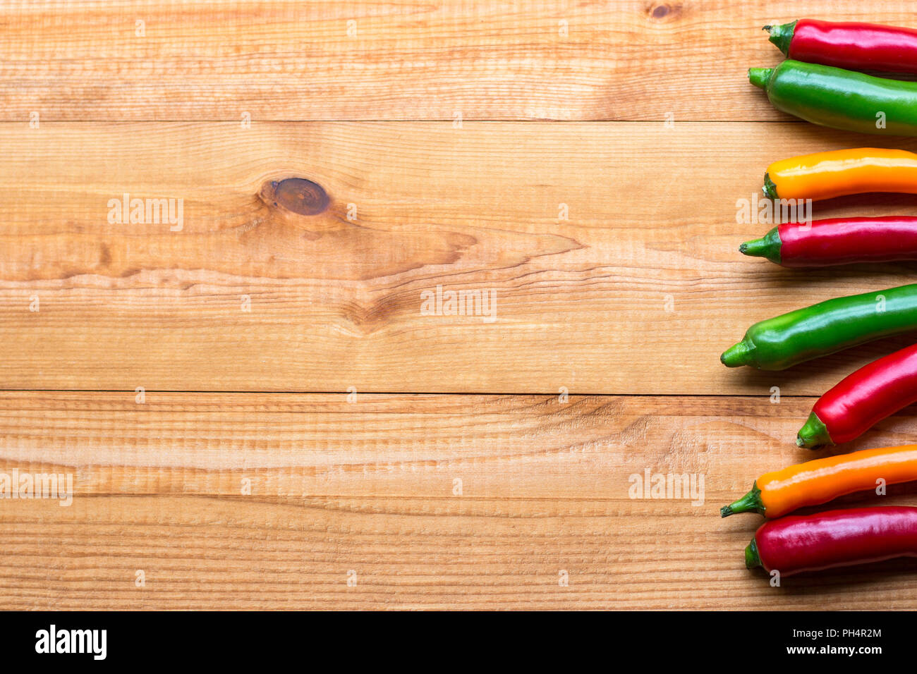 chilli peppers on wooden background Stock Photo - Alamy
