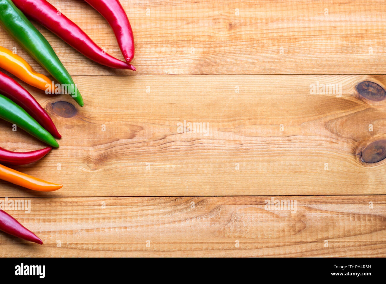 chilli peppers on wooden background Stock Photo - Alamy
