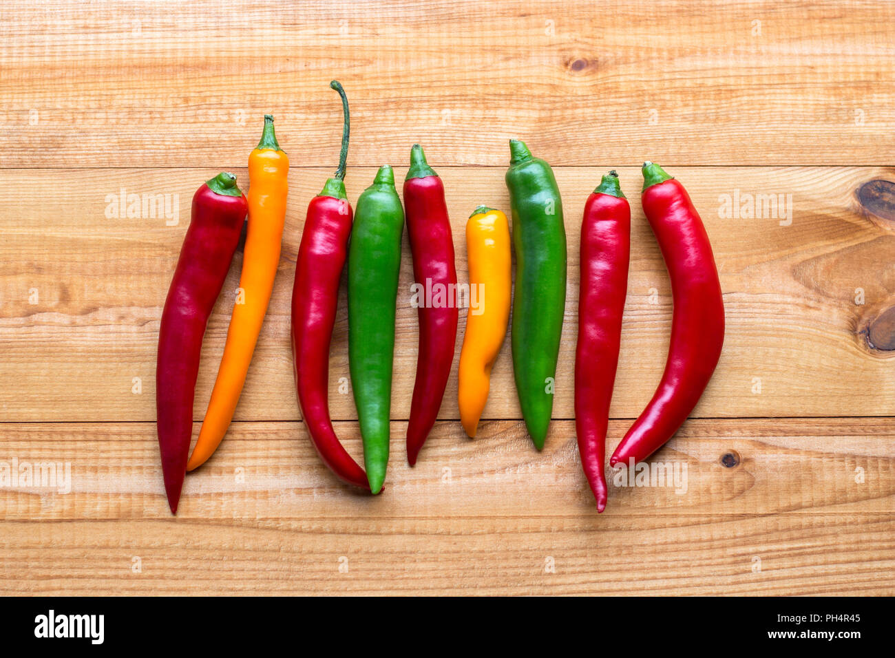 chilli peppers on wooden background Stock Photo - Alamy